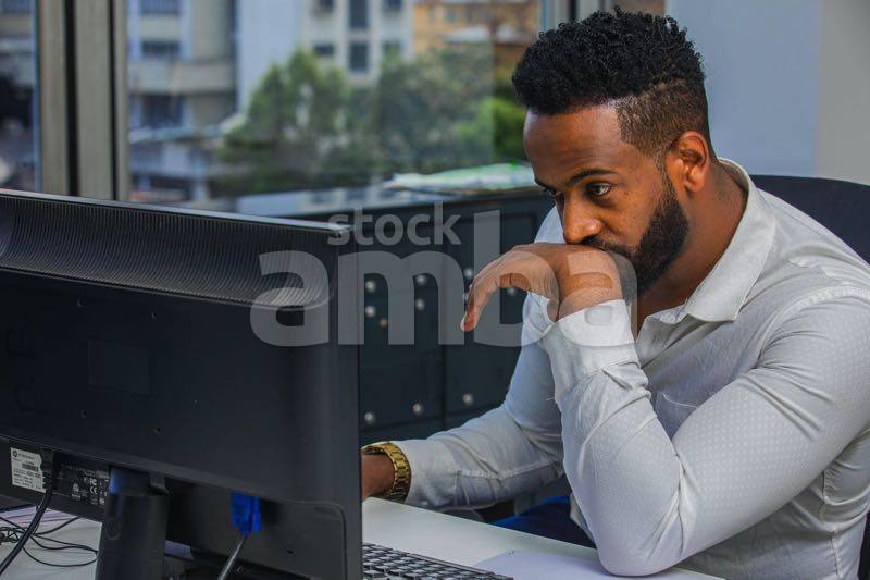 A Man Using Computer While Working in the Office - StockAMBA.com
