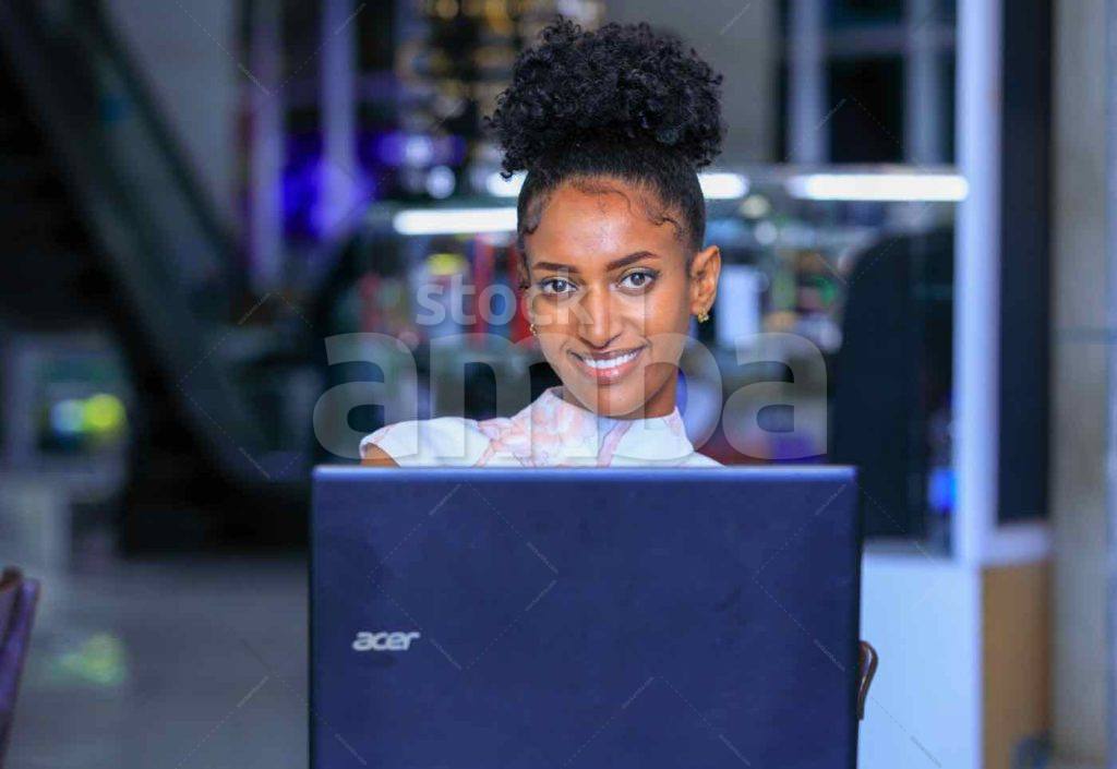Girl with her Laptop Looking at Camera - StockAMBA.com