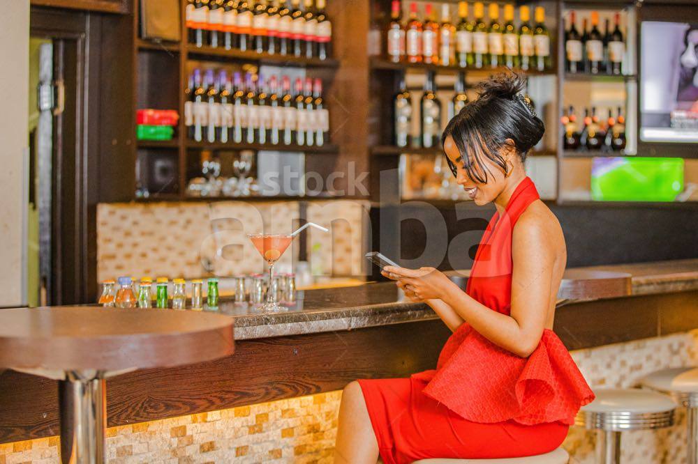 Happy Girl Capturing her Memories in the Bar - StockAMBA.com
