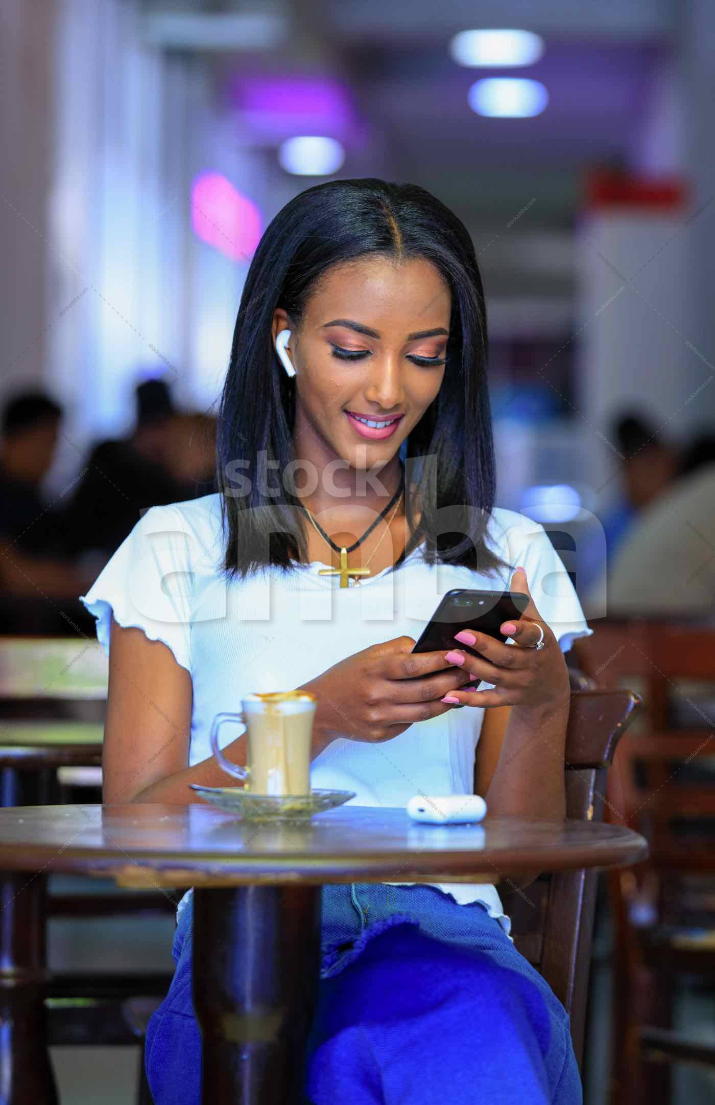 Woman Typing Message on her Phone - StockAMBA.com