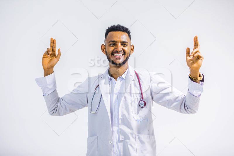 A Doctor Wearing White Coat with Stethoscope Pointing Aside with Index ...