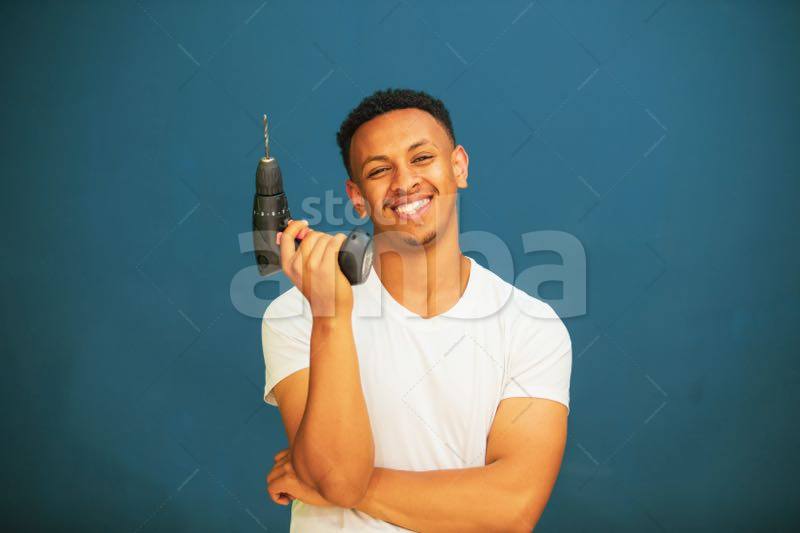 Young Man with an Electric Drill - StockAMBA.com